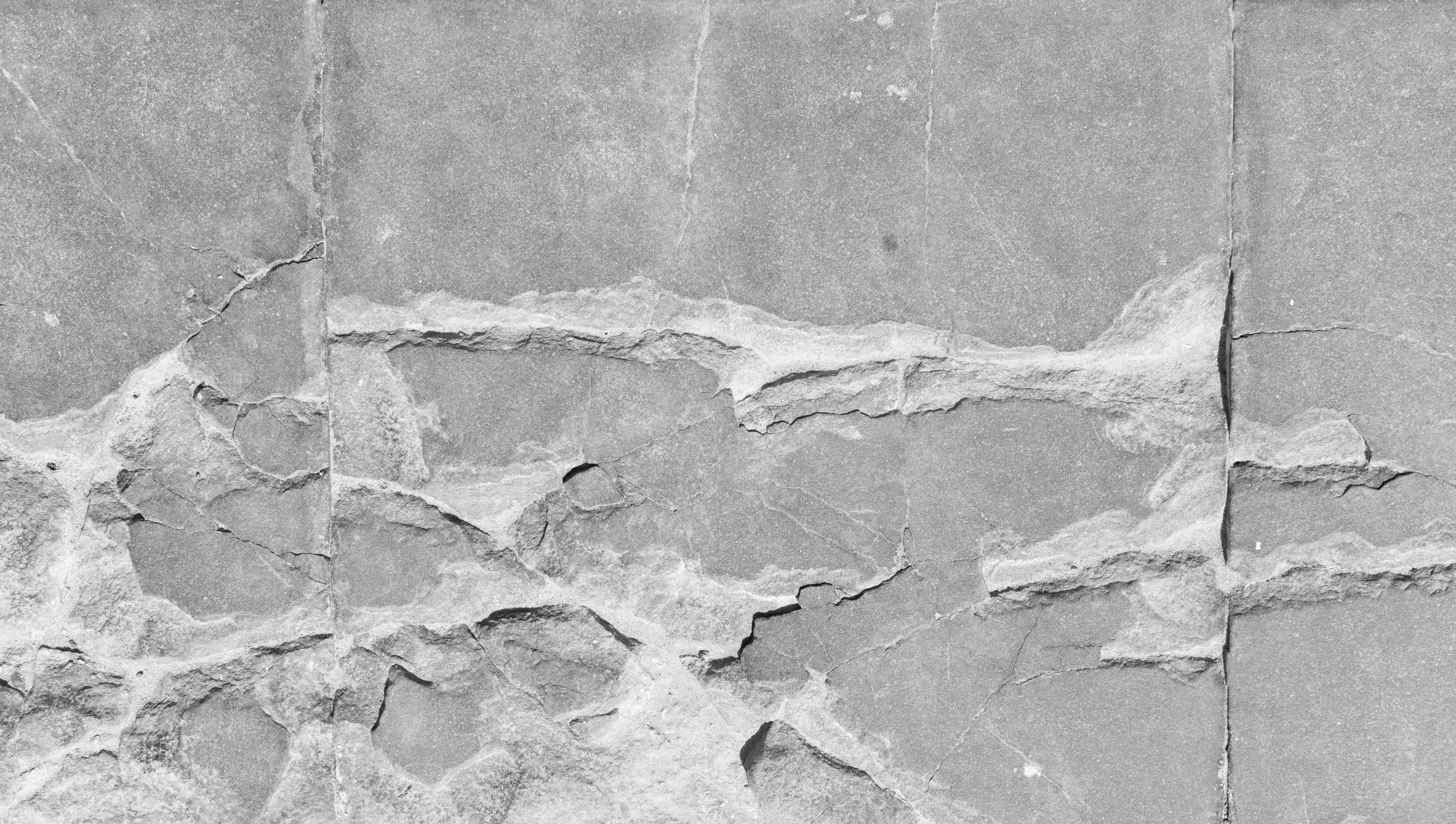 Rough grey stone surface with cracks and uneven texture. photo ...