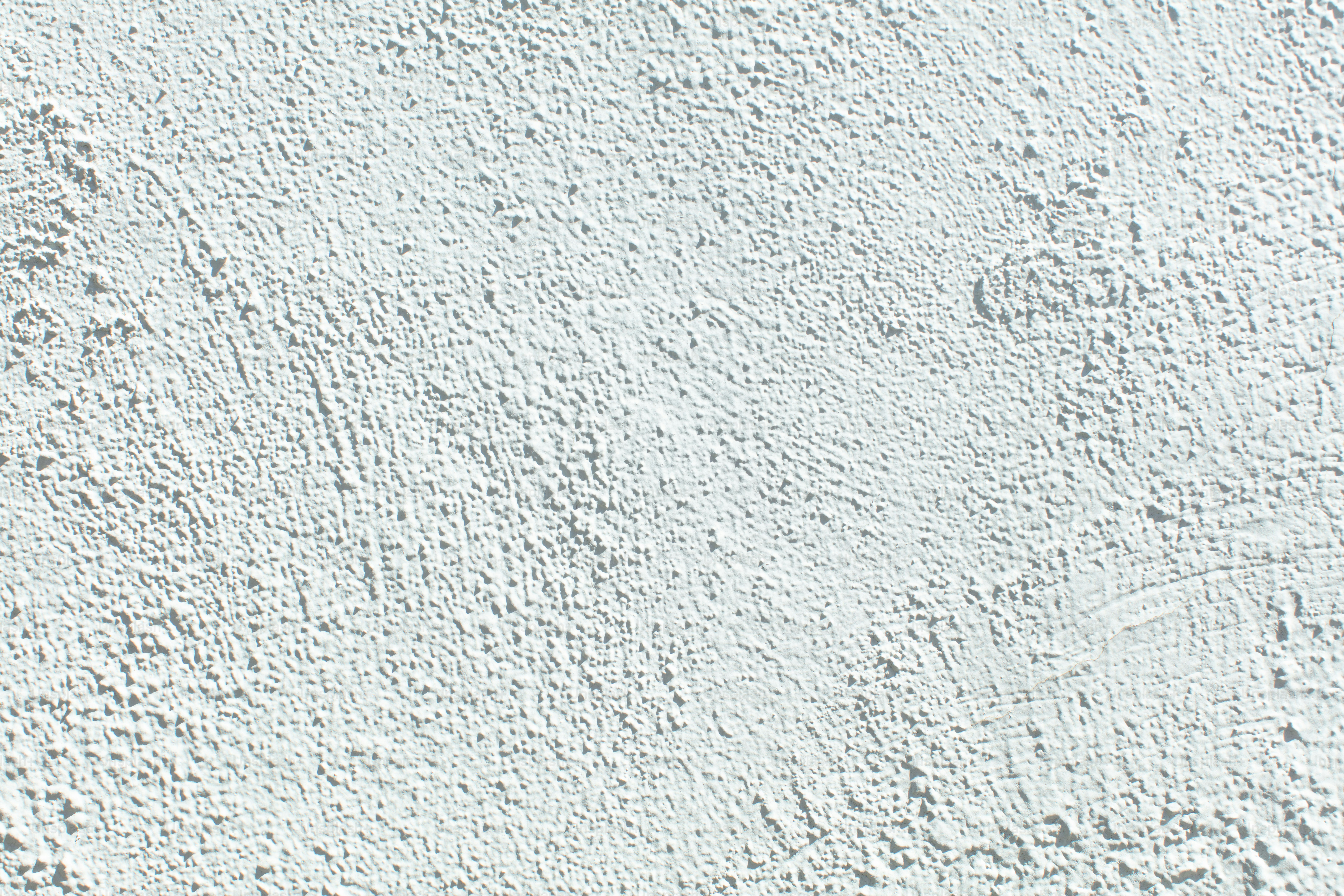 Textured white surface with an irregular brown stain and holes. photo ...