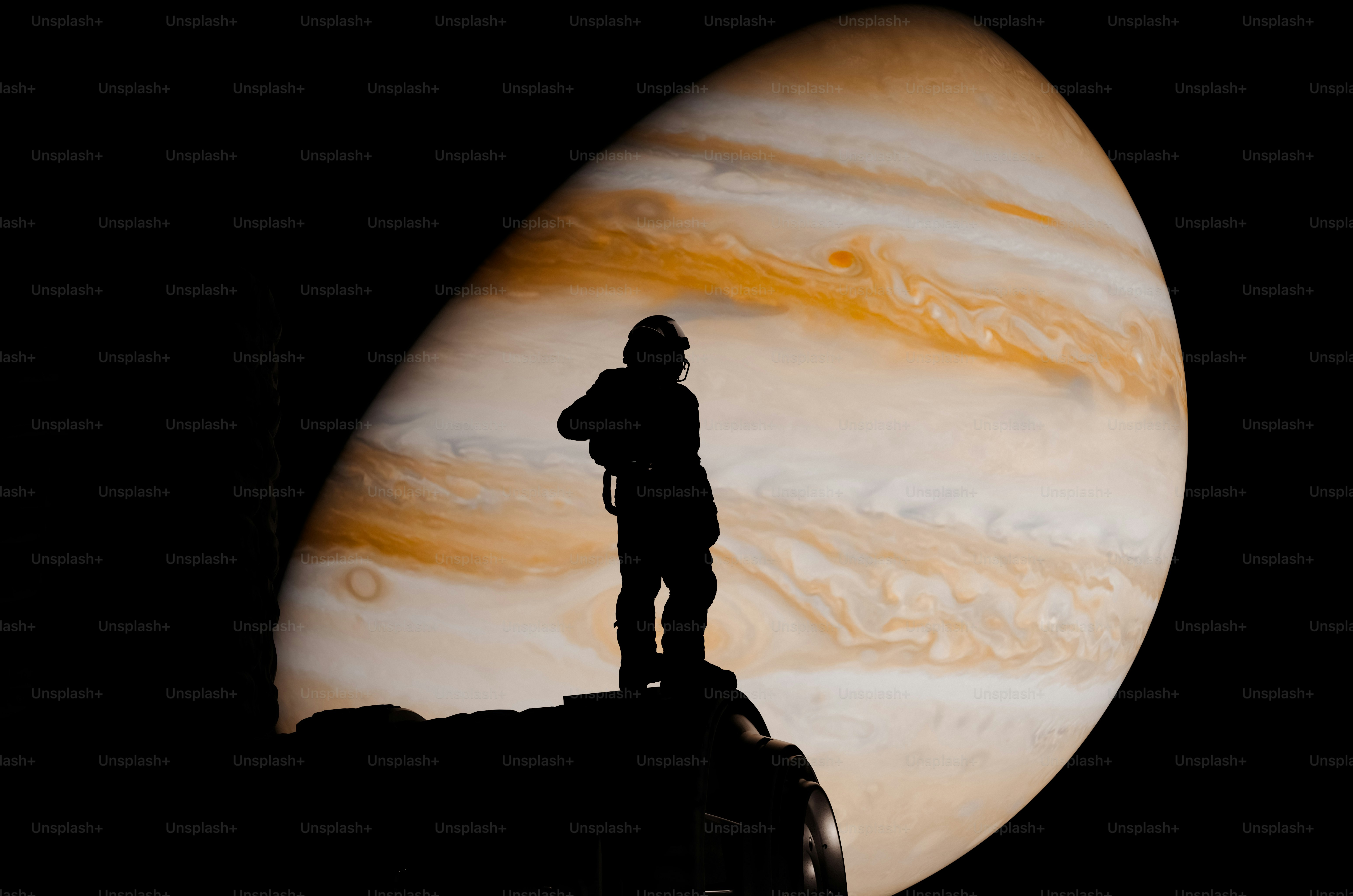 Astronaut silhouette on cliff against jupiter's swirling clouds. photo ...