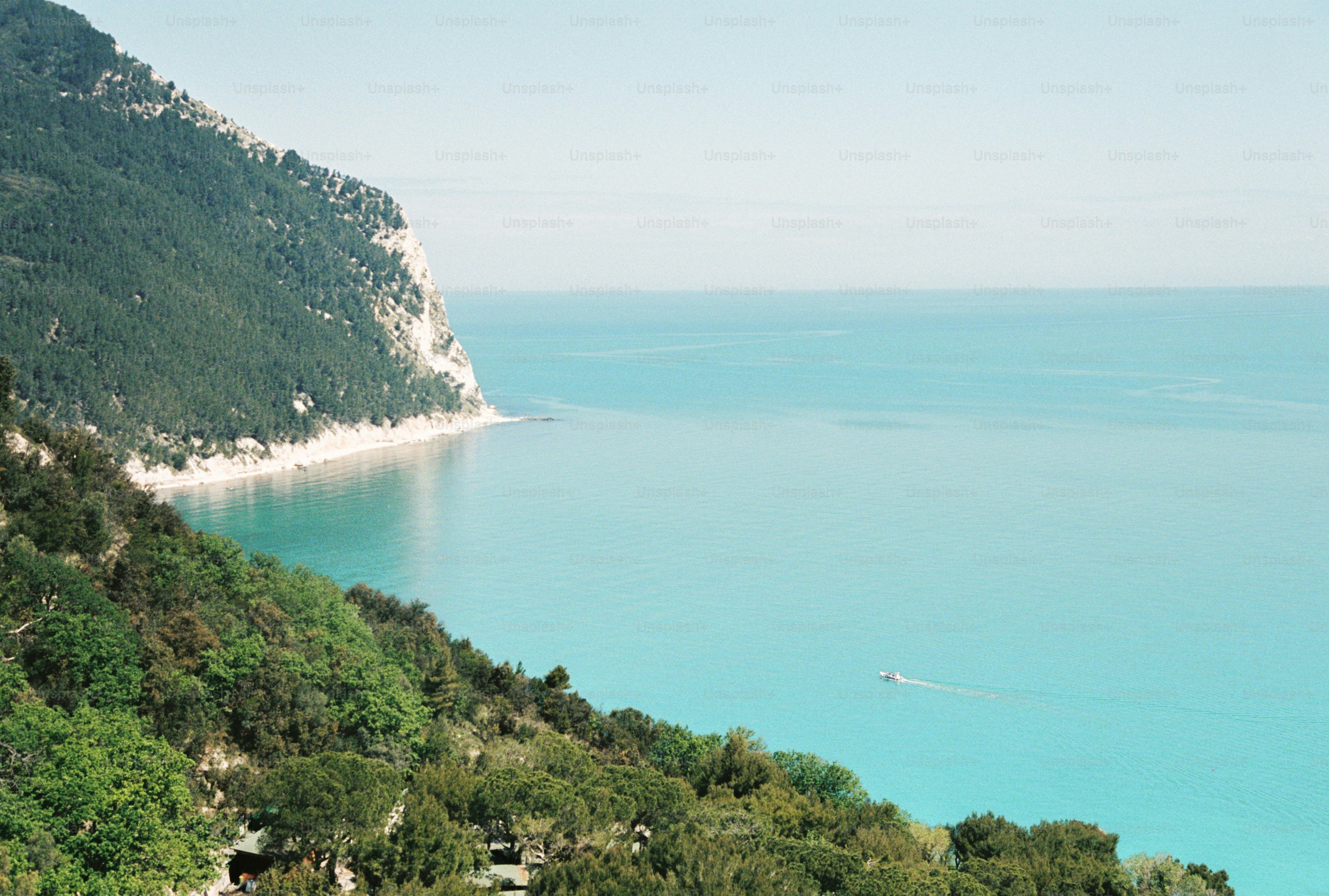 Sandy beach with rocky cliffs and turquoise ocean water. photo ...