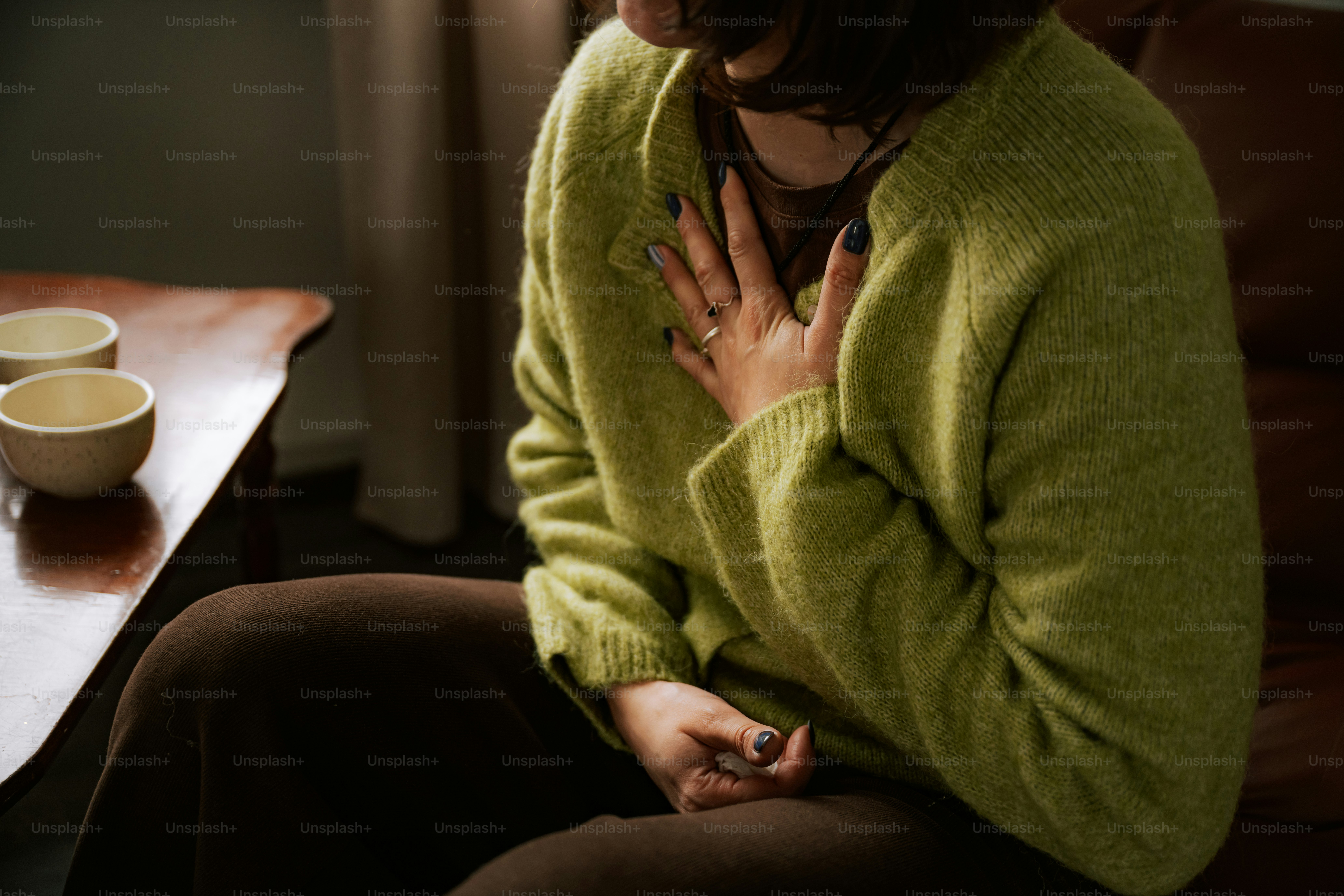 Woman holding chest, indicating discomfort. photo – Mental health Image ...