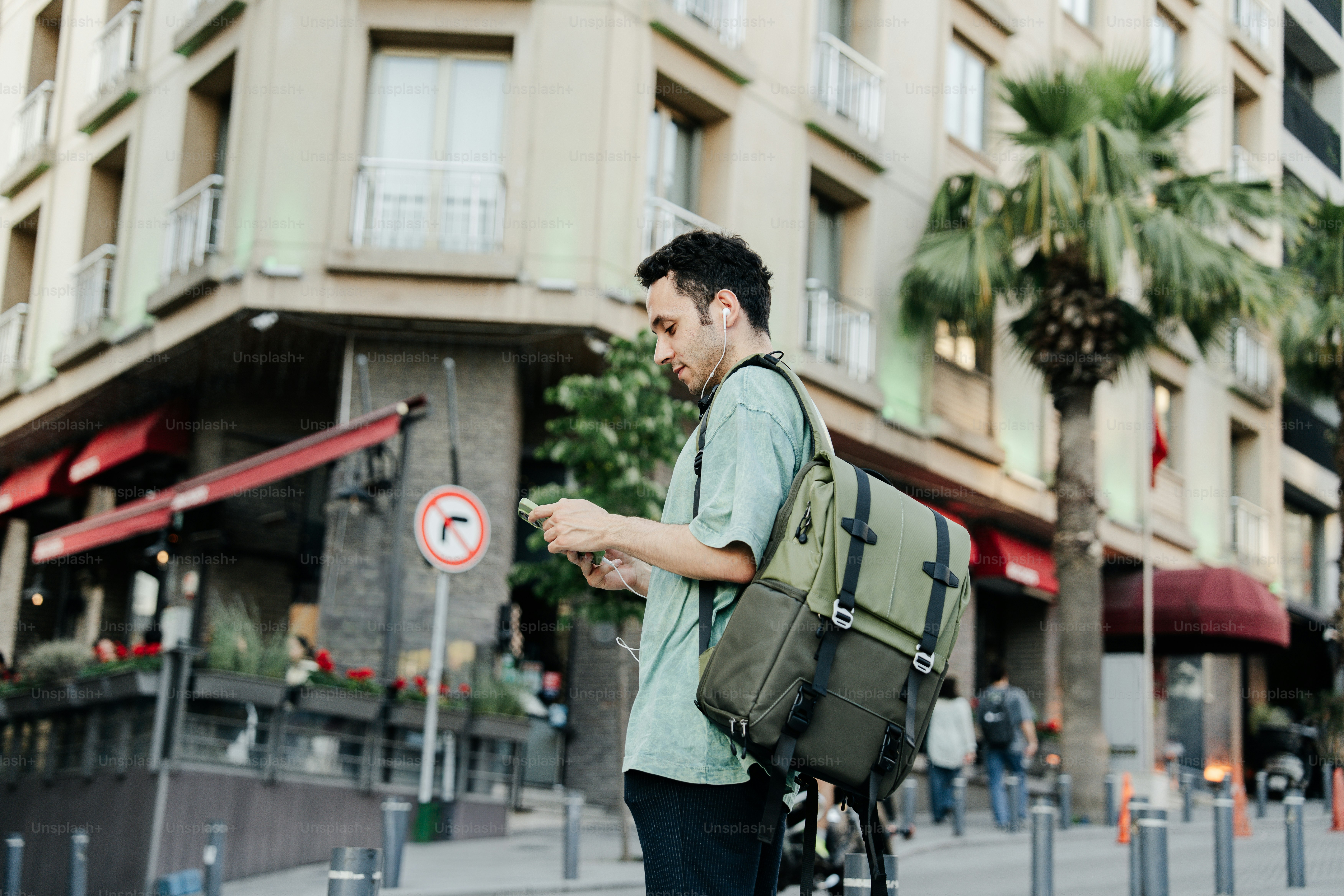 Man with a delivery bag looking at his smartphone outdoors. photo ...